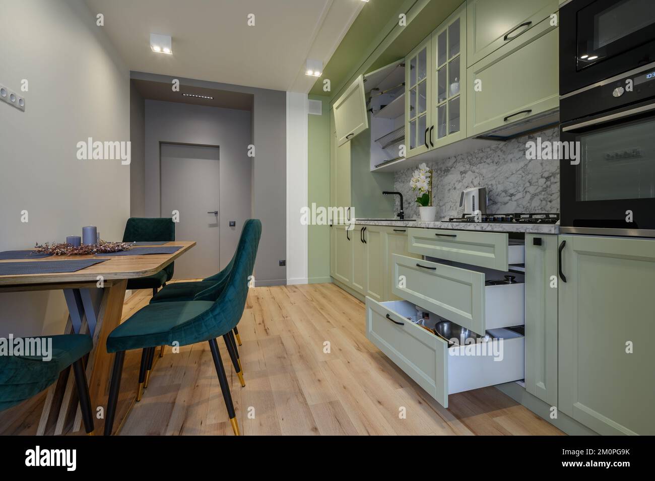 Modern light green luxurious kitchen with dining table Stock Photo - Alamy