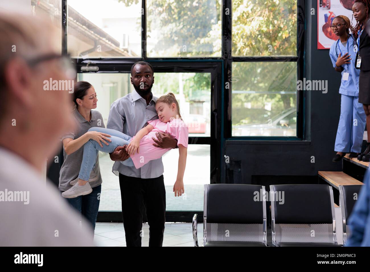 Worried father entering in hospital waiting area holding unconscious ...