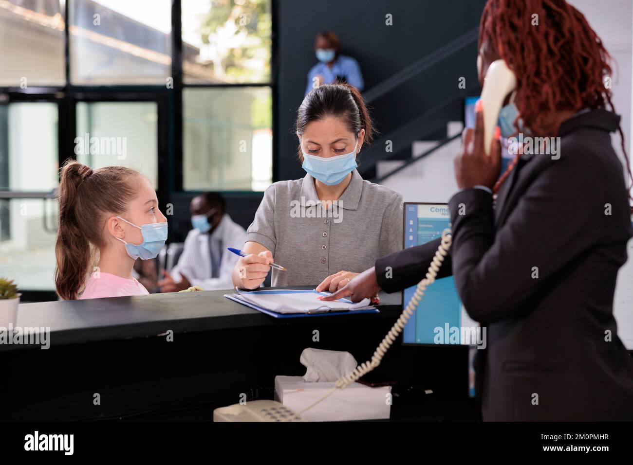 Kid waiting mother to sign medical insurance papers standing at ...