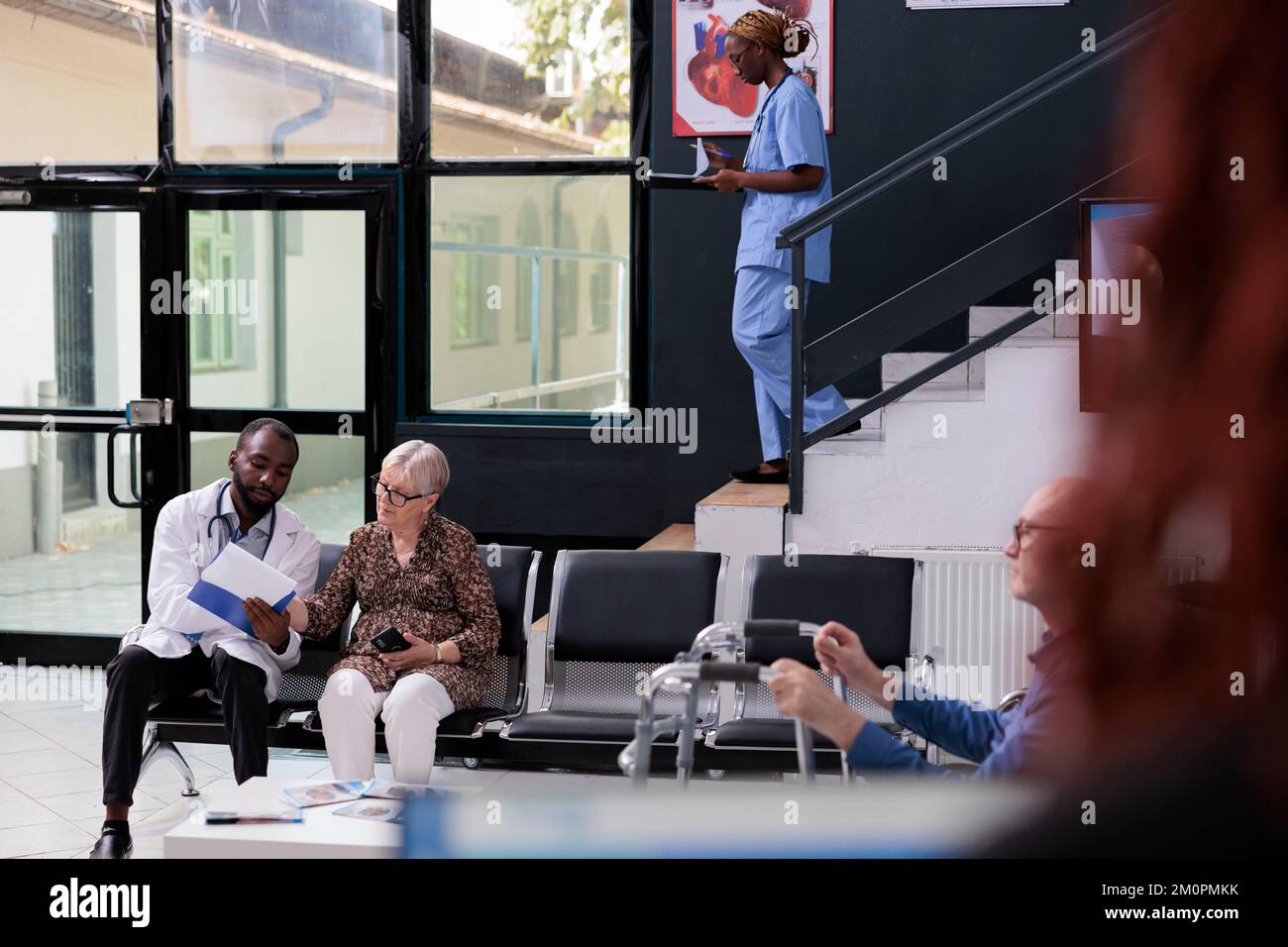 Elderly patient patient looking at papers with medical report while ...
