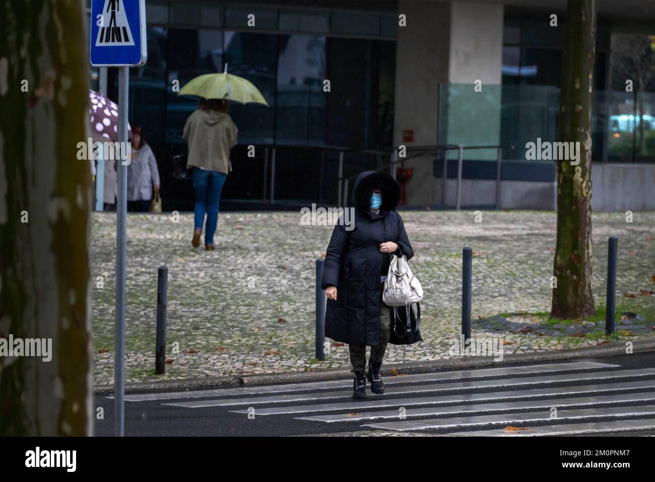 People using umbrellas are seen walking the streets of the Oriente area ...