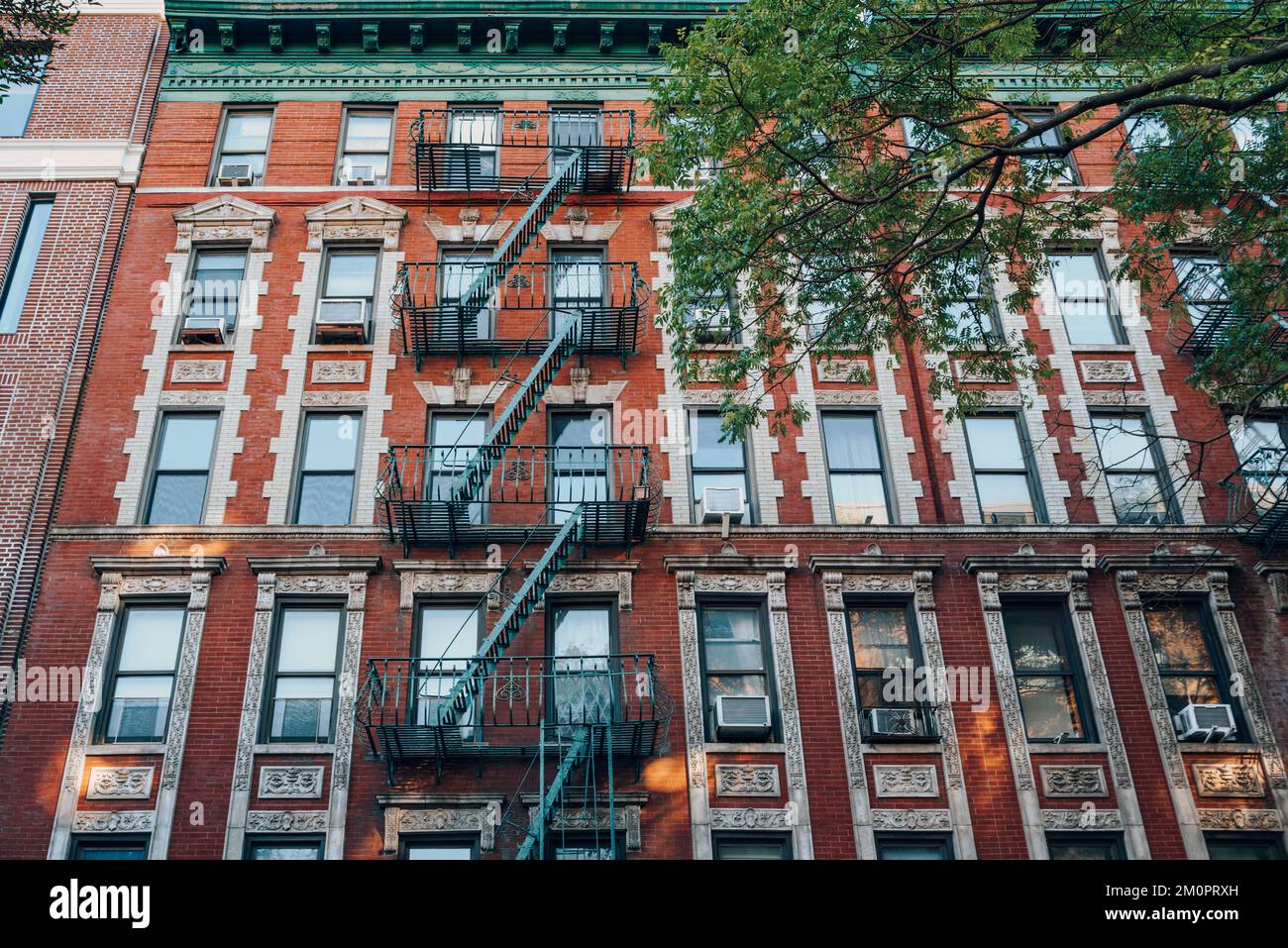 Facade of a typical red brick New York apartment block with fire escape ...