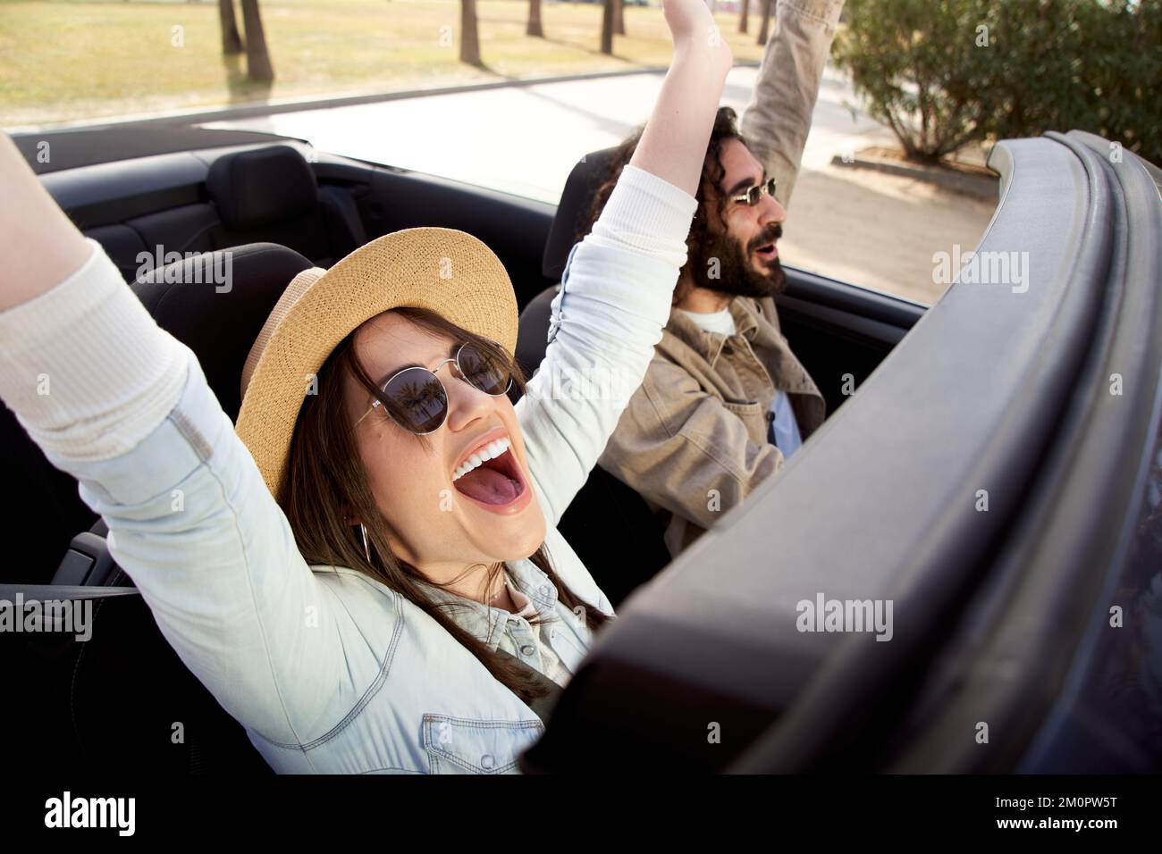 Happy couple friends enjoying dancing in the car Sitting in front seat ...