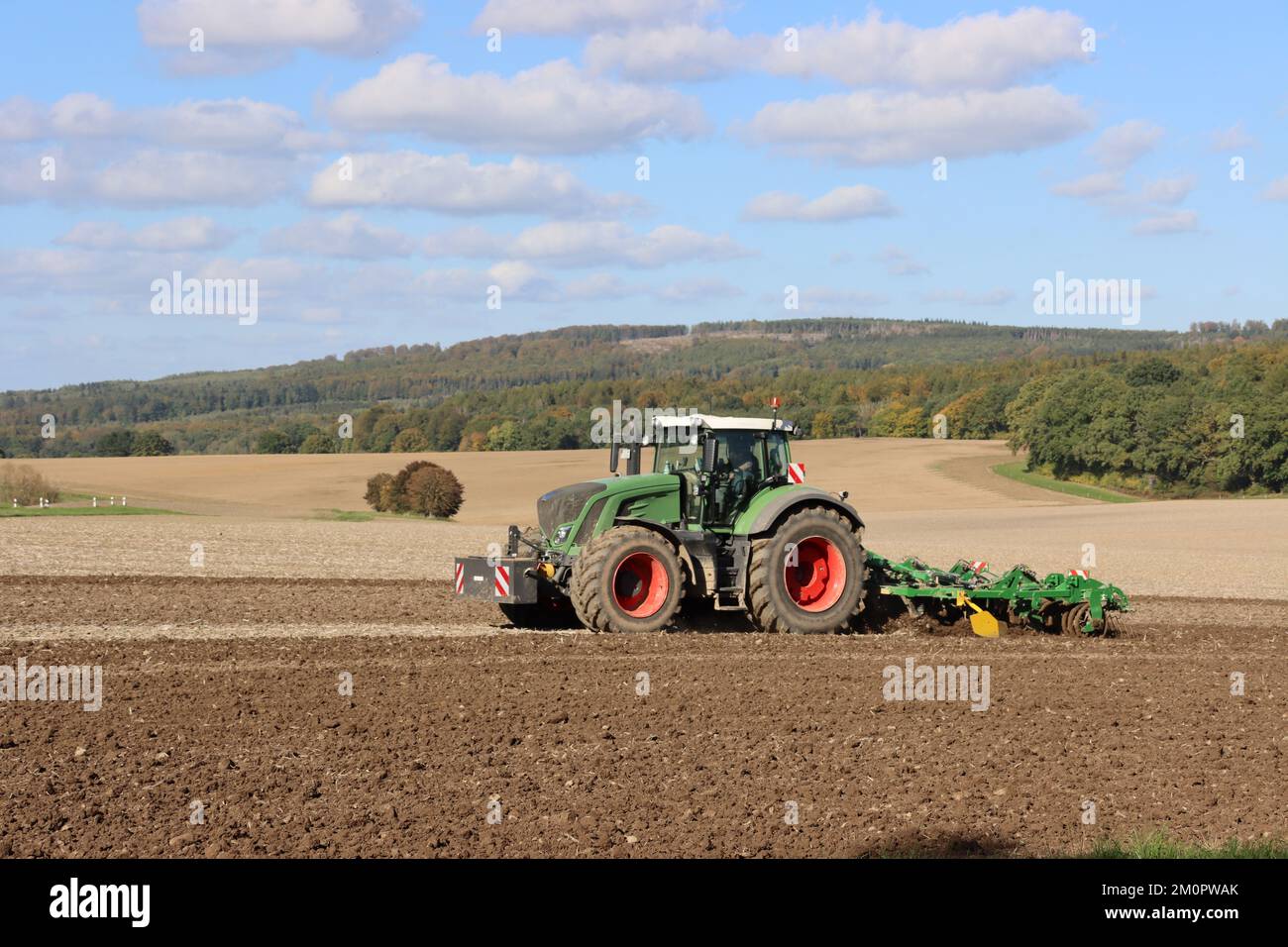 Landwirt eggt mit seinem Traktor ein Feld nahe der Sababurg, Hessen ...