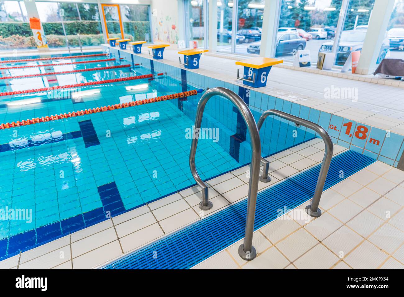 Stainless-steel pool ladder at professional sports indoor swimming pool ...