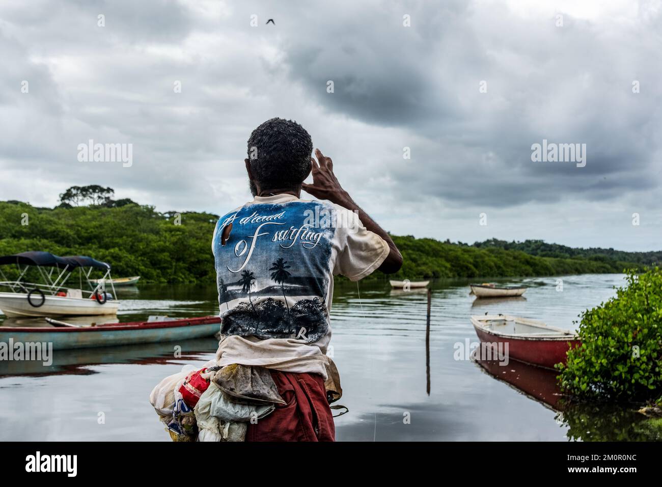 Fisherman throwing bait to catch fish on the edge of the Jaguaripe ...