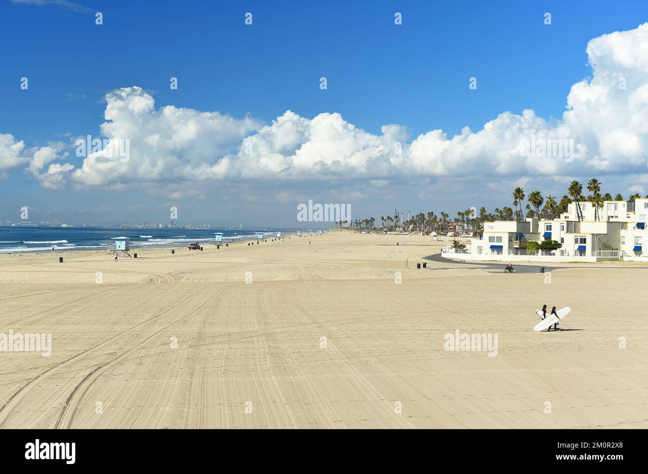 HUNTINGTON BEACH, CALIFORNIA - 7 DEC 2022: Two Surfers draging their ...