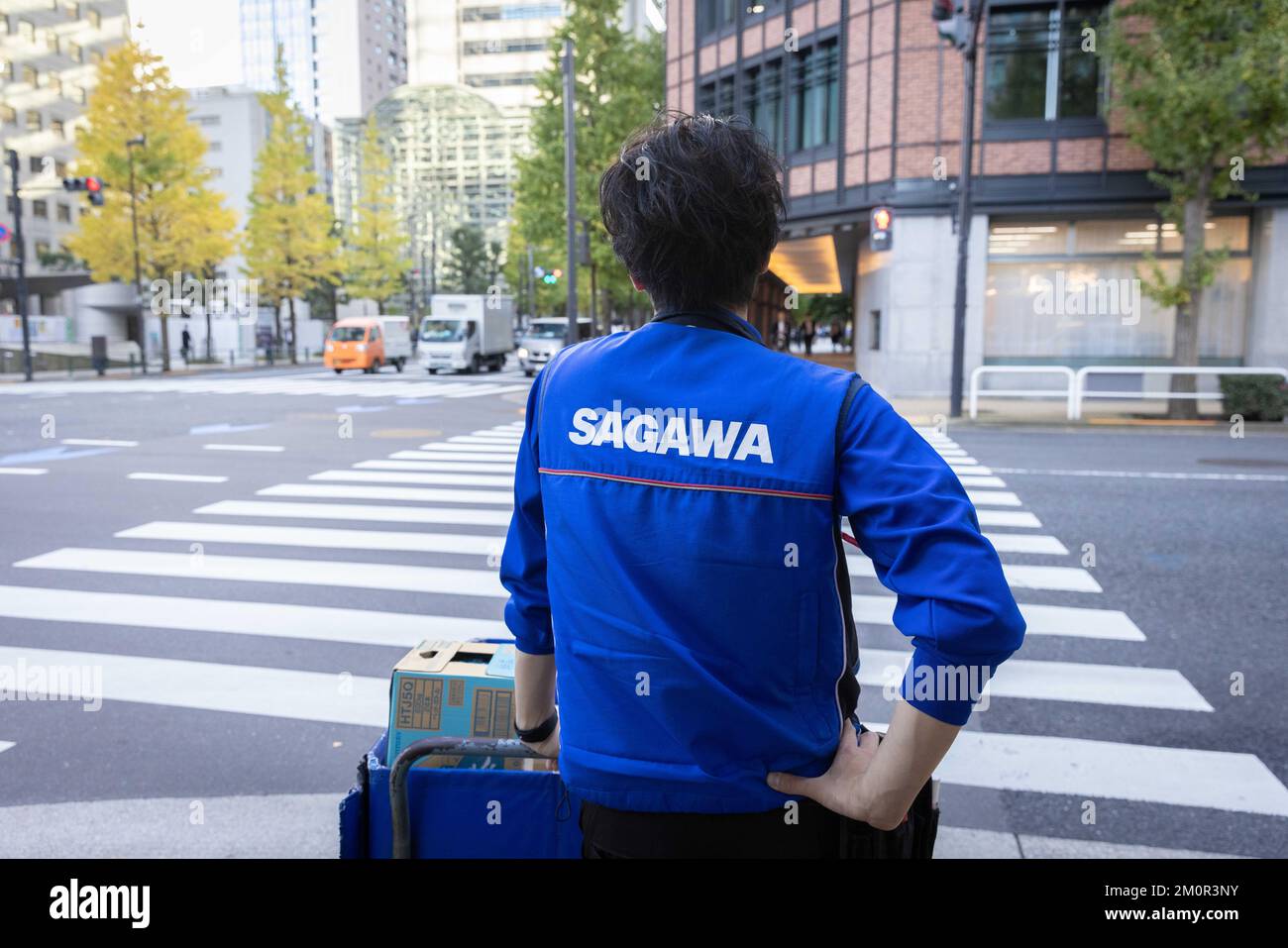 Sagawa Express deliveryman waits at a traffic light in Otemachi, Tokyo ...