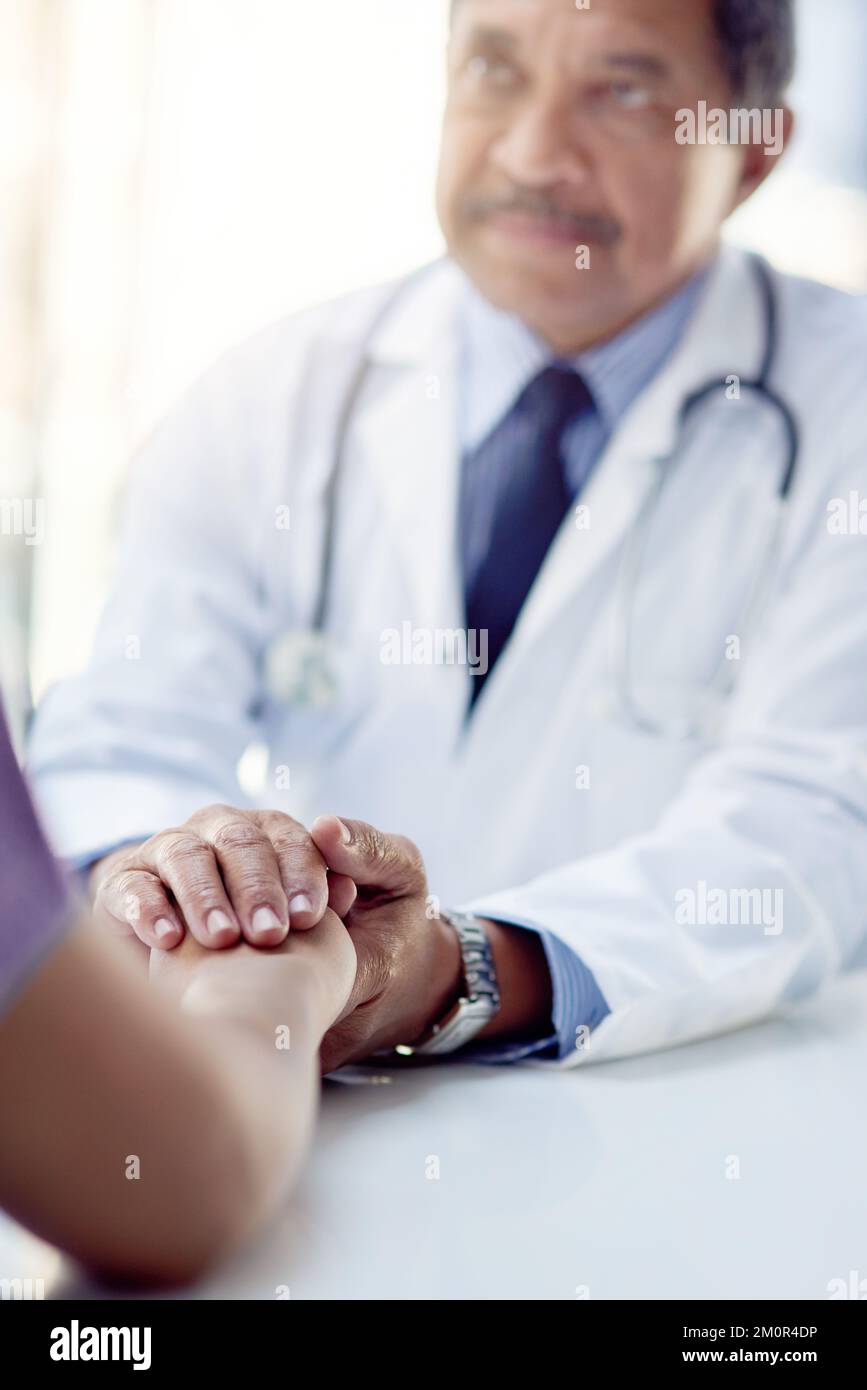 Leave your health in his capable hands. a doctor holding a patients ...
