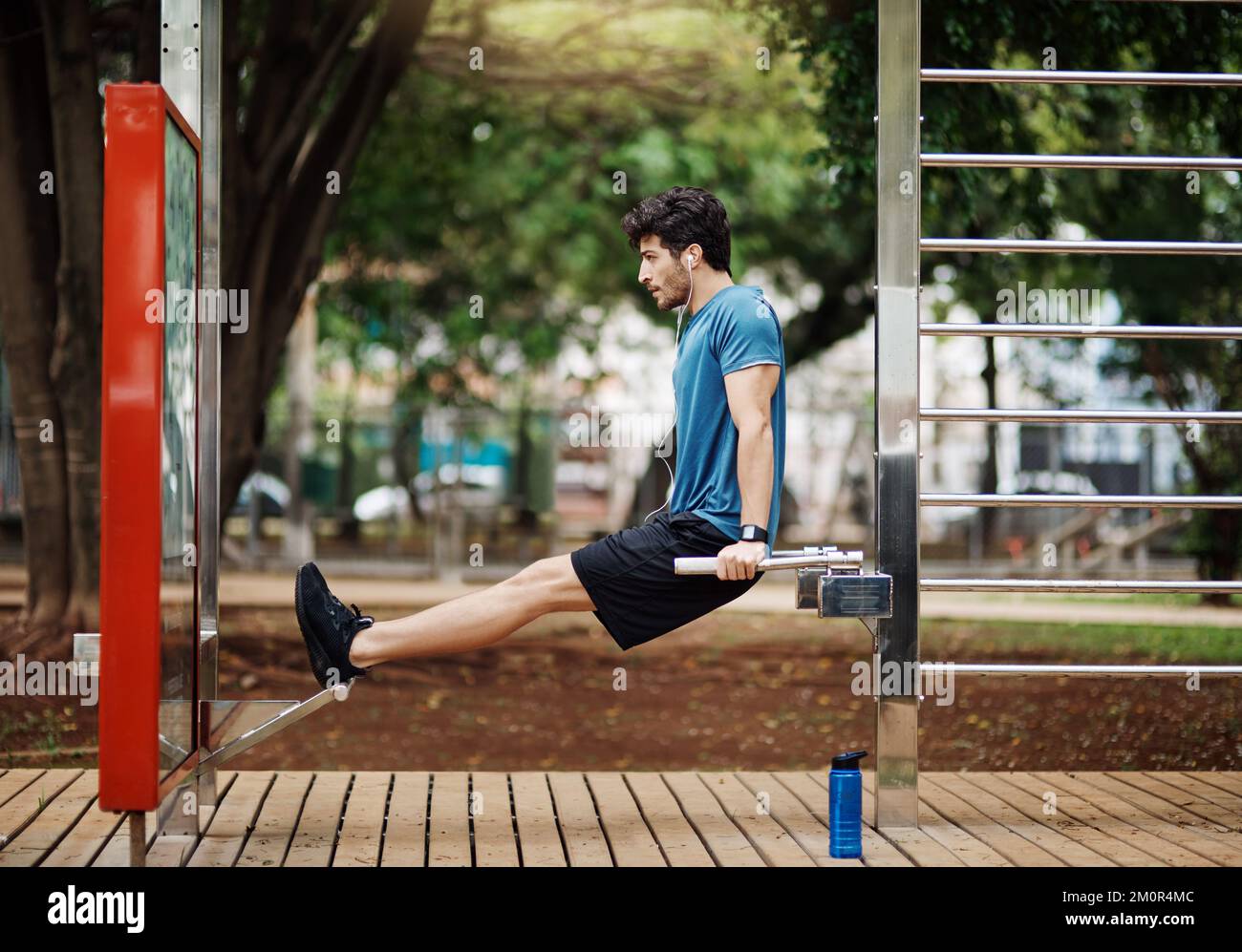 Up and down. a sporty young man doing stretching techniques while ...