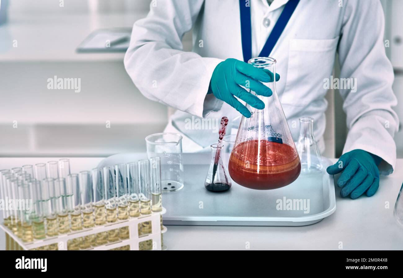 Lets mix this a little. an unrecognizable female scientist conducting an experiment with a red ...