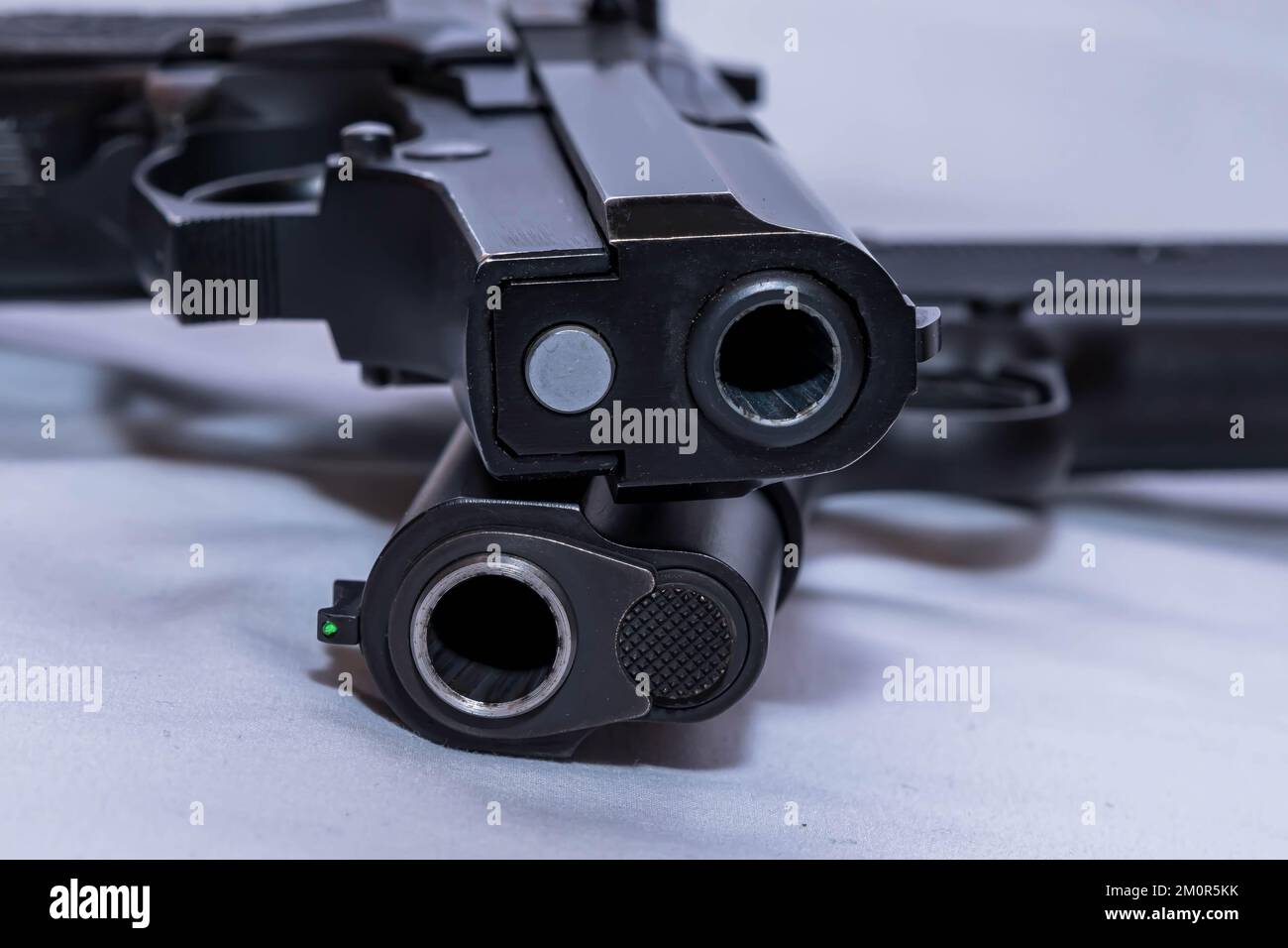 Two black pistols stacked on top of each other, a 40 caliber and a 45 ...