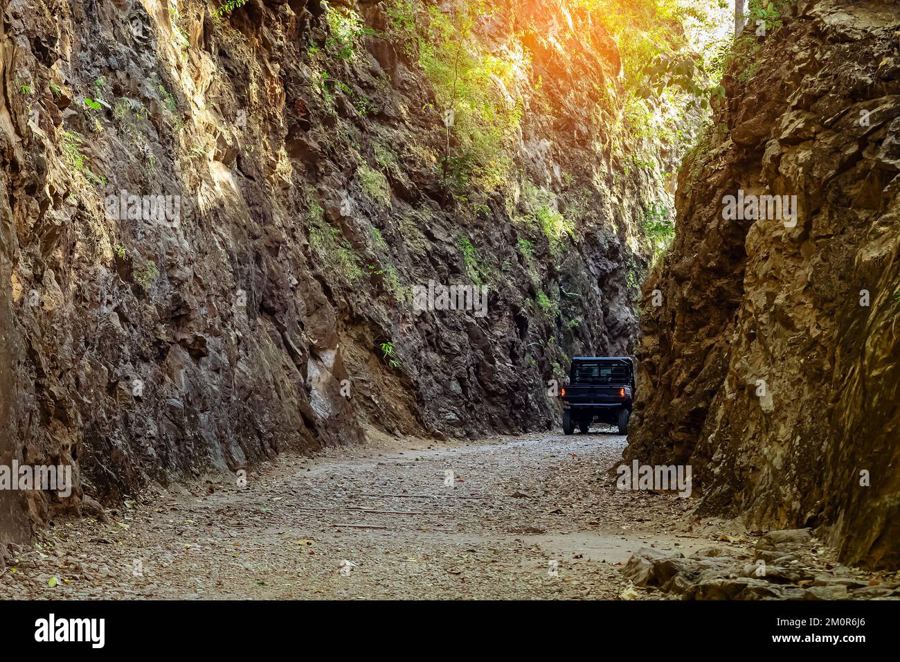 Tourist SUV car cruising along a rugged route through the gorge that ...