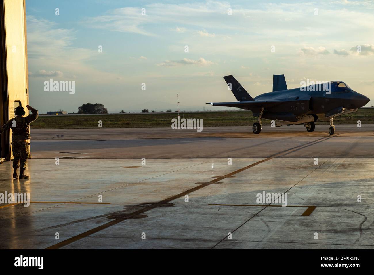 A U.S. Air Force Airman marshals an F-35 Lightning II back into its ...