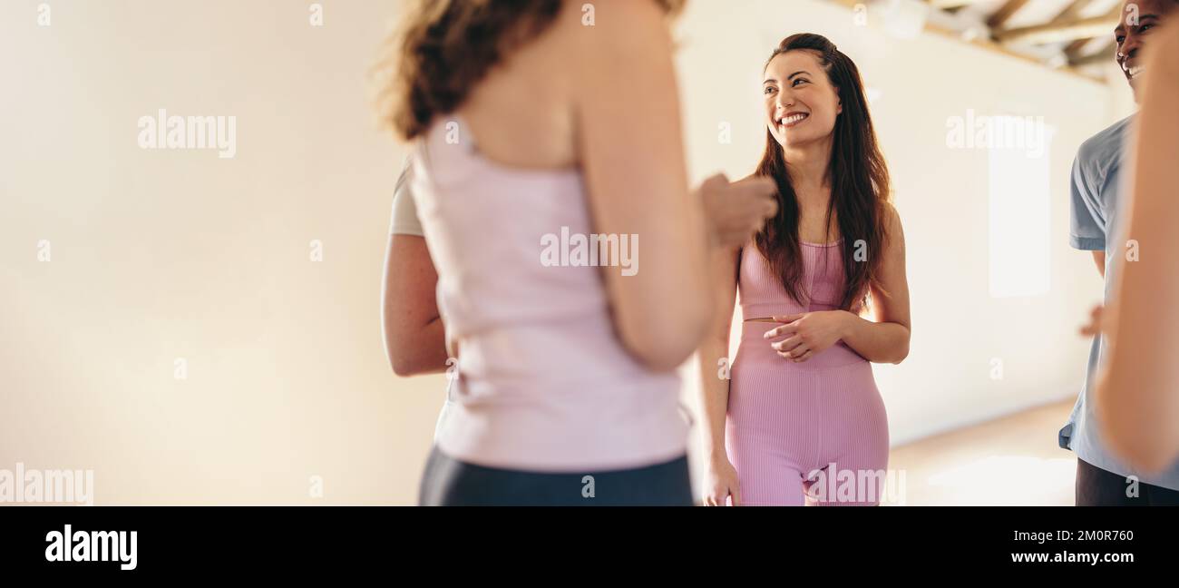 Group of happy fitness people talking to each other while standing in a ...