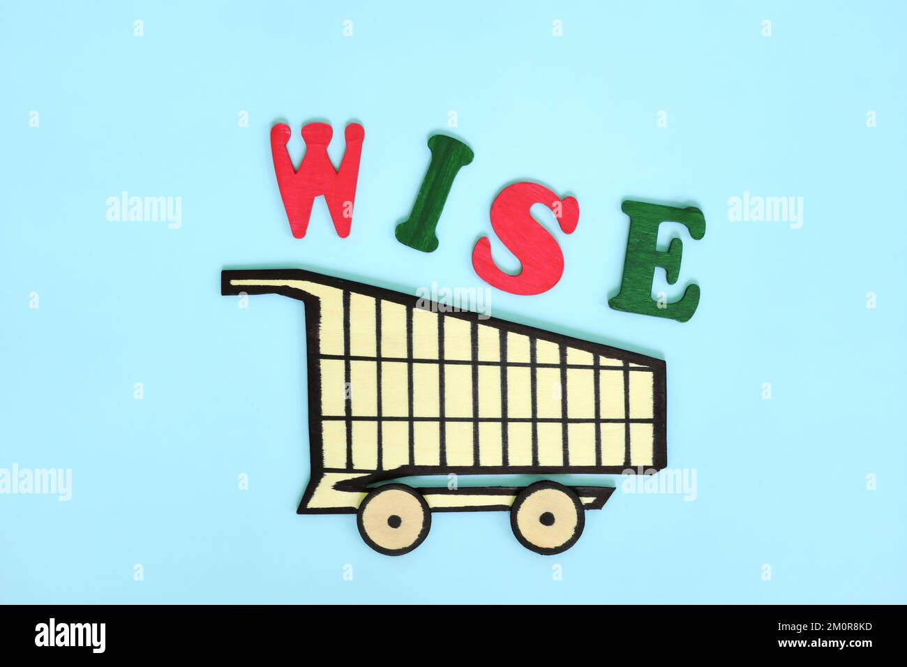 Shop wise and smart concept. Wooden shopping cart with word in blue ...