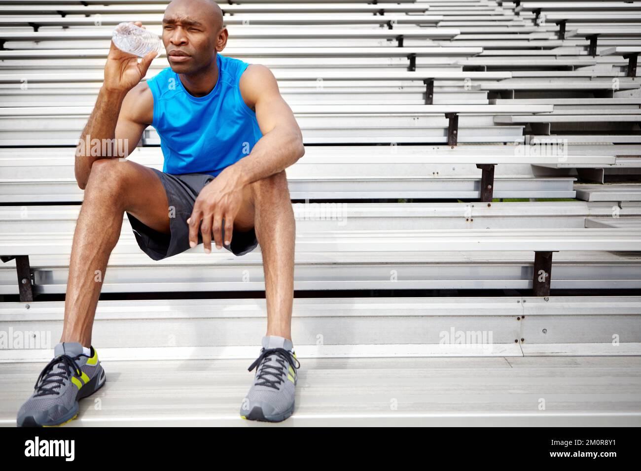 Hydrating while contemplating his next run. Full length shot of a male ...