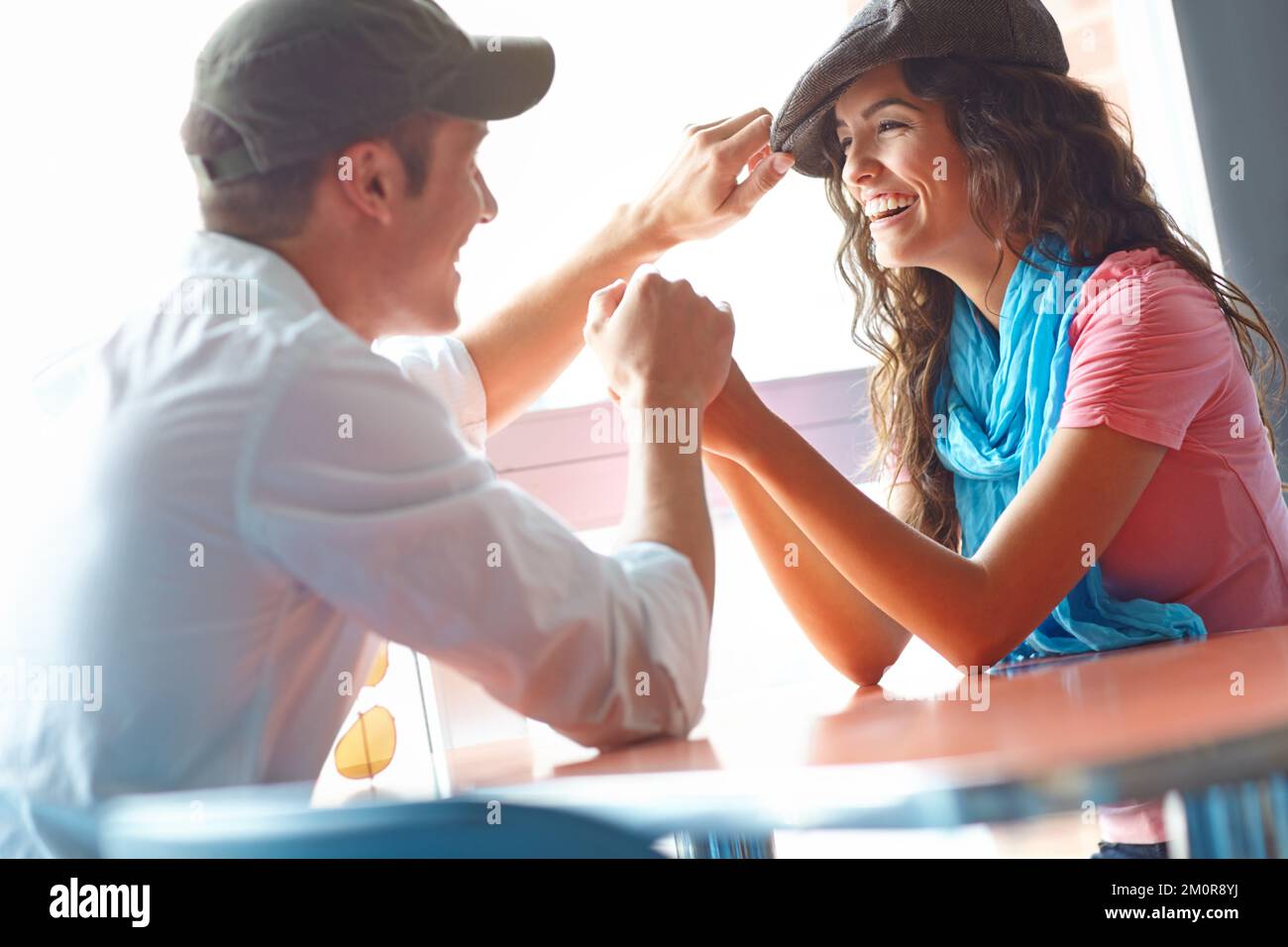 You look so cute in your hat. A young man playfully pulling his ...