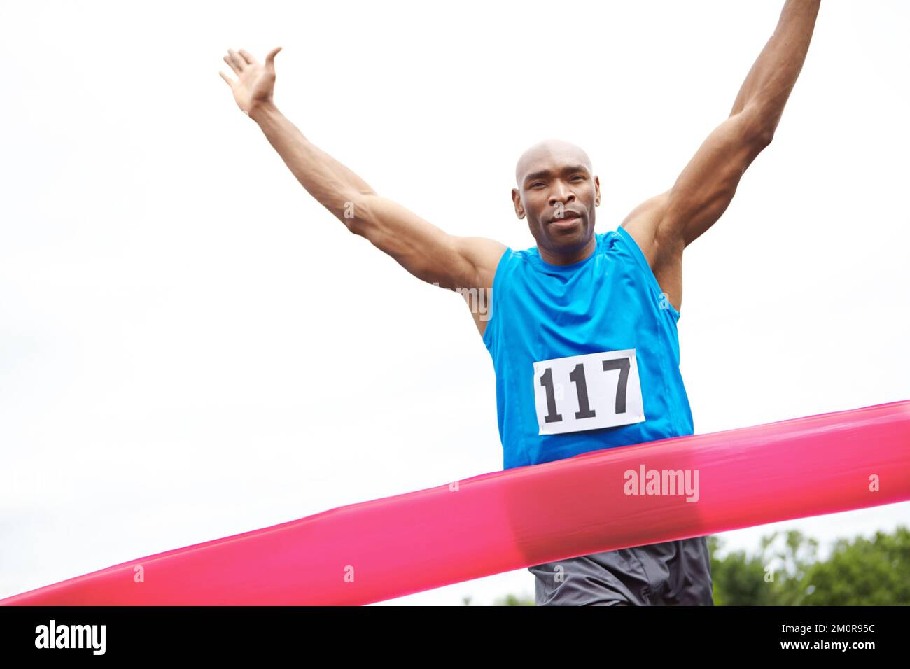 Ending in a win. Cropped front view of a male athlete winning a race ...