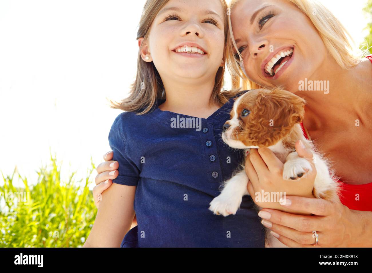 I adore my little girl. a little girl holding a puppy while her mother ...