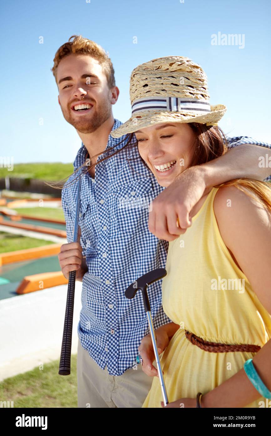 Youre never too old for mini-golf. A happy young couple playing putt ...