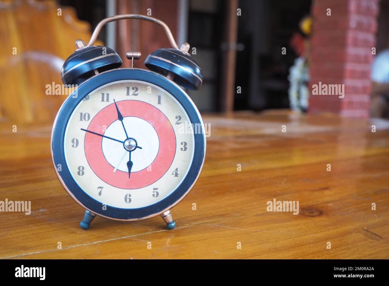 An antique clock placed on a wooden table Stock Photo - Alamy