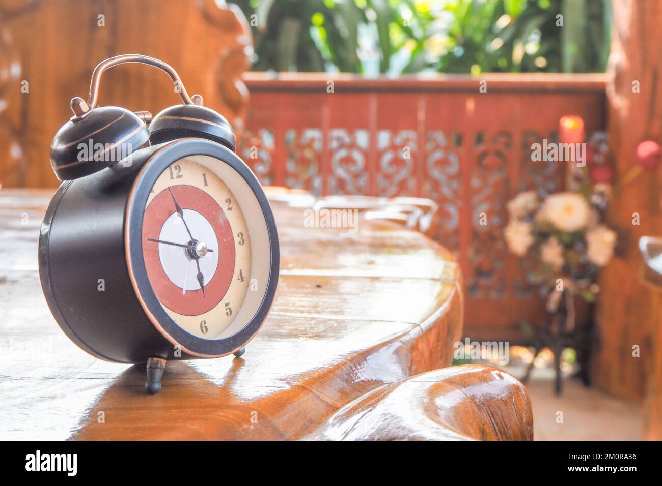 An antique clock placed on a wooden table Stock Photo - Alamy