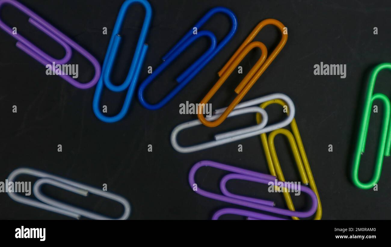 Colorful paper clips isolated on black background Stock Photo - Alamy