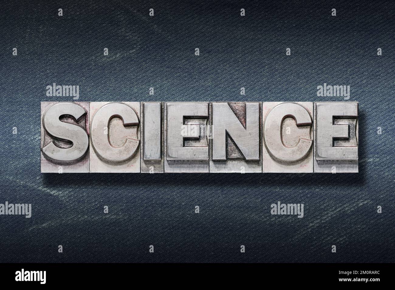 science word made from metallic letterpress on dark jeans background ...