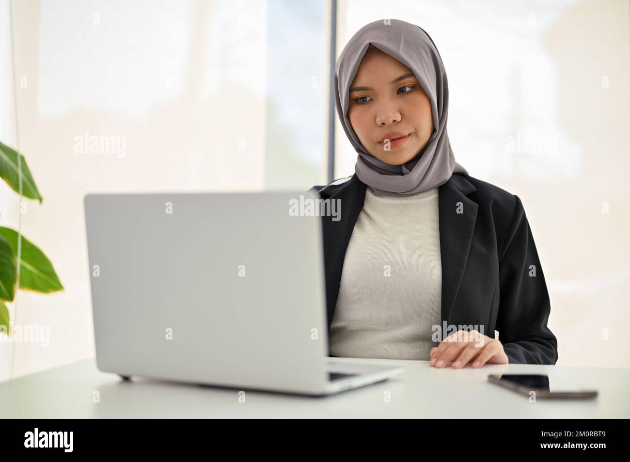 Professional Asian Muslim businesswoman or female boss focusing on her ...