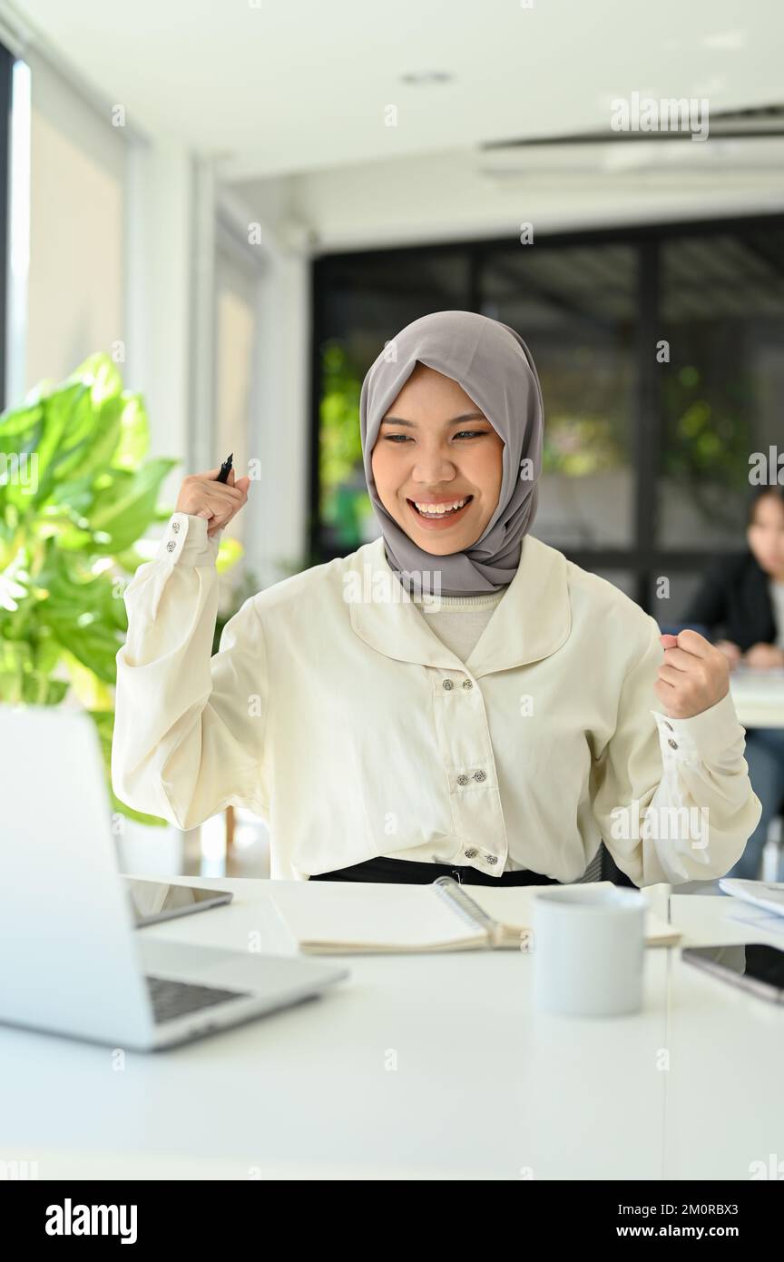 Portrait, Happy young Asian Muslim female office worker hands up ...