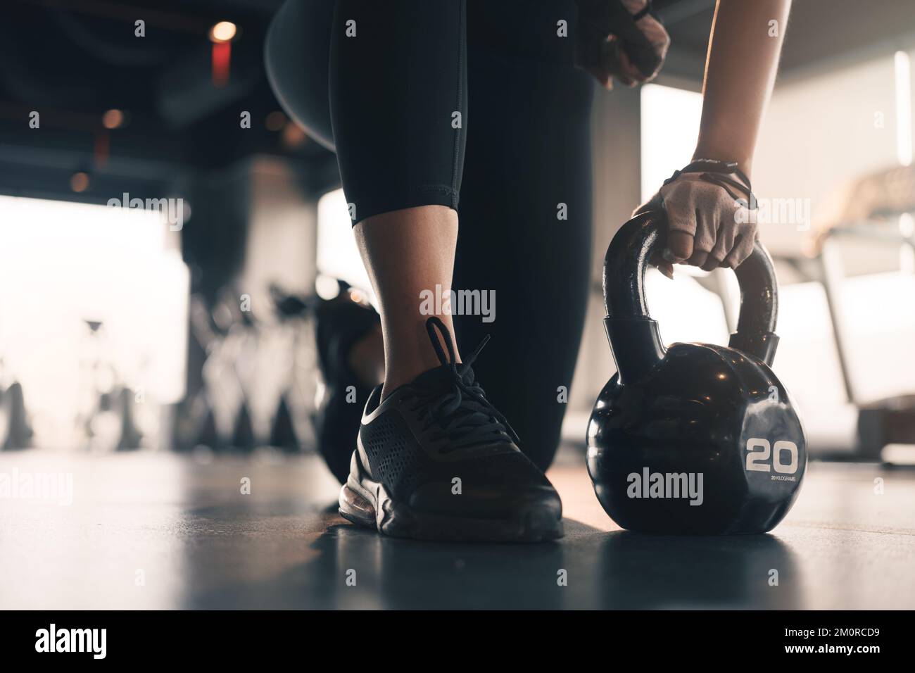Sporty woman lift kettlebell in upper arm exercise to build muscle at ...