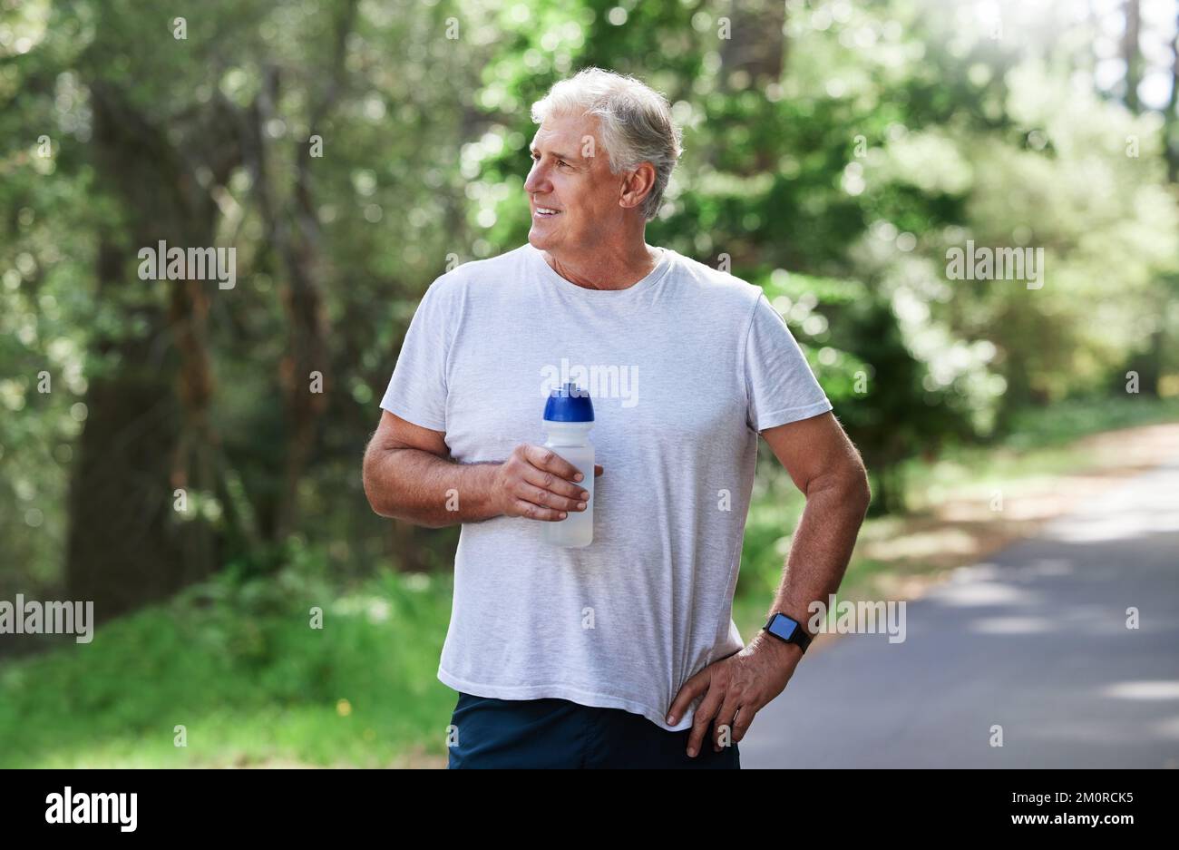 I feel tons more refreshed now. a mature man drinking water while ...