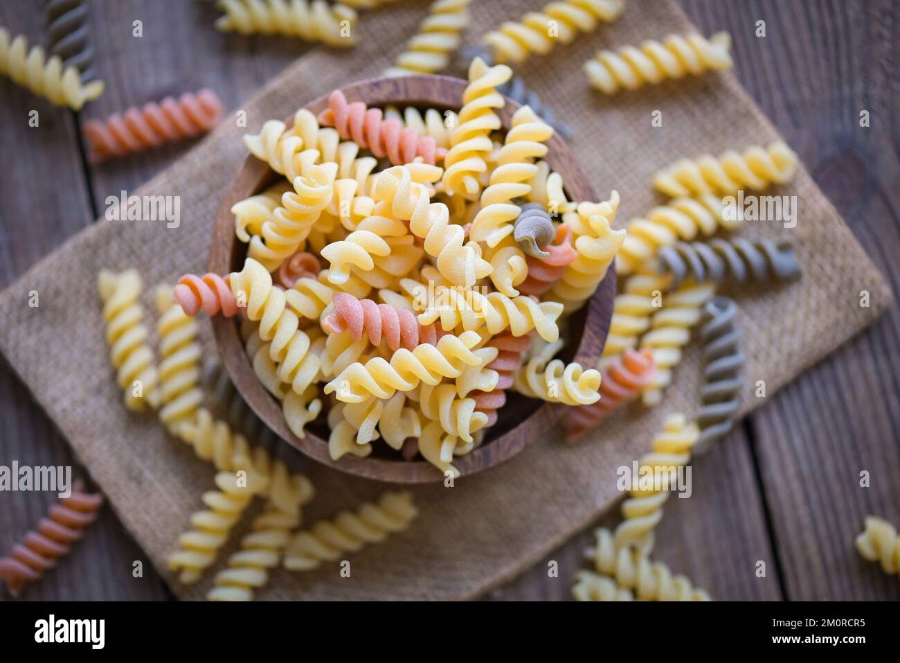 Pasta raw macaroni on wooden bowl background, close up raw macaroni spiral pasta uncooked ...