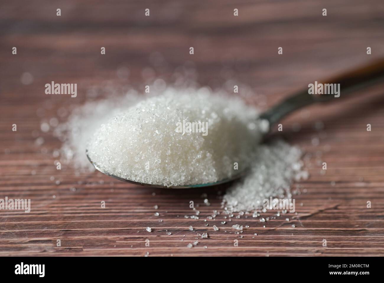 Sugar on spoon and wooden background, white sugar for food and sweets ...