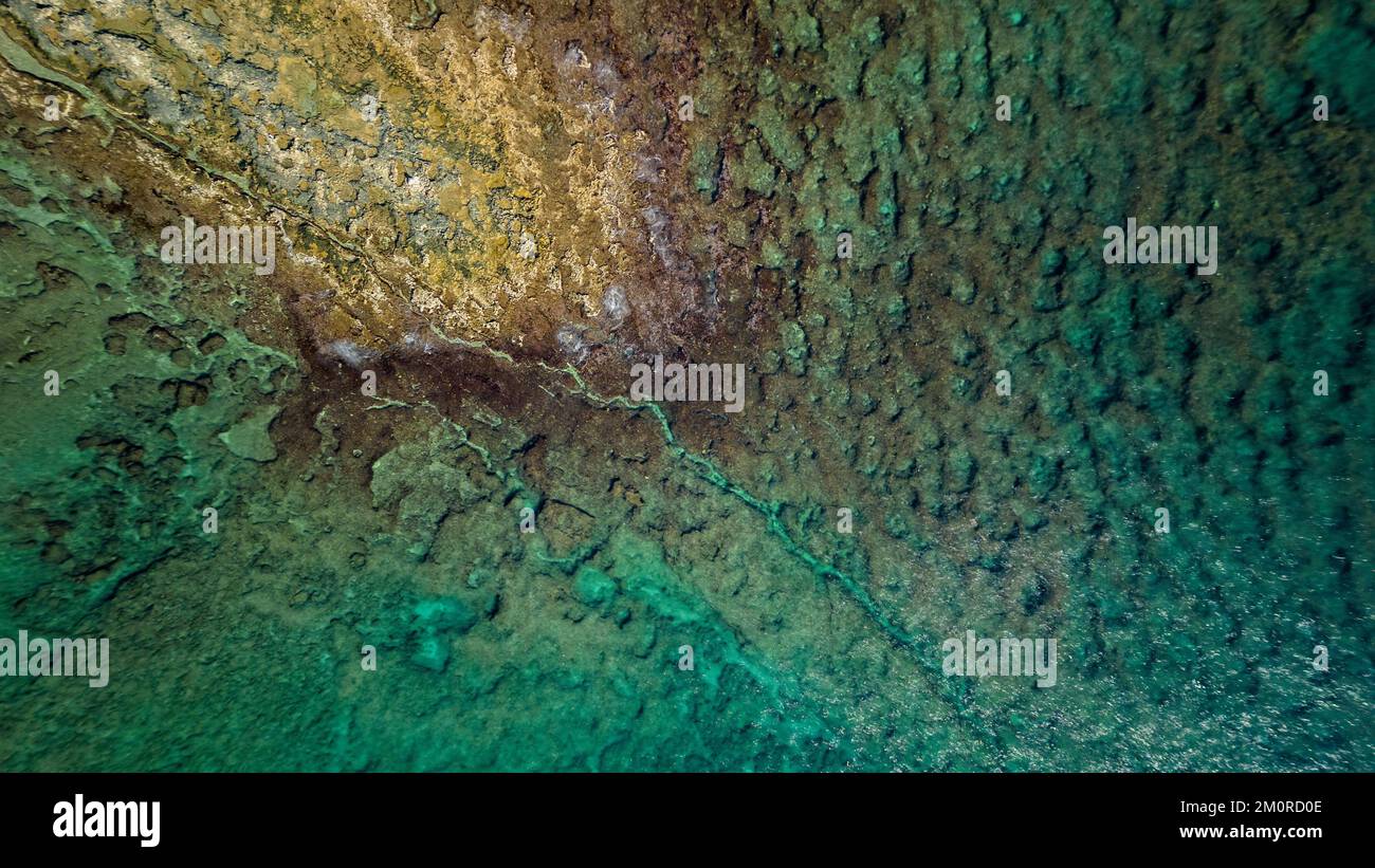 An aerial top view of a rocky beach against a turquoise sea Stock Photo ...