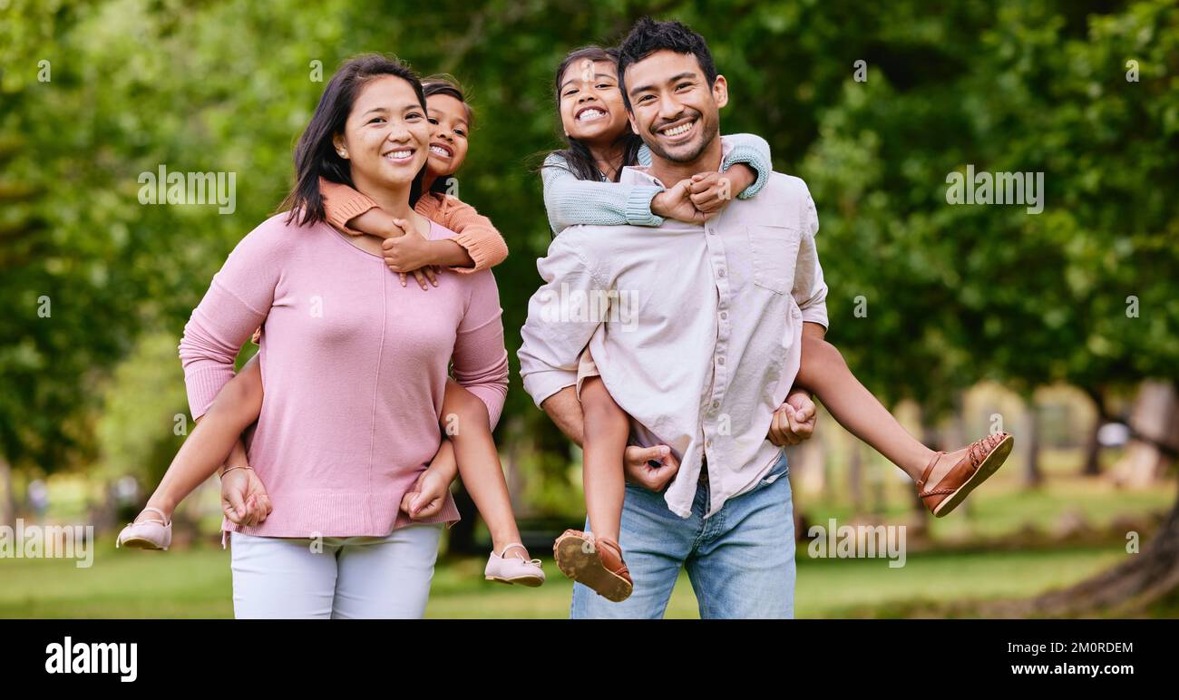 Young happy mixed race family relaxing and walking together in a park ...