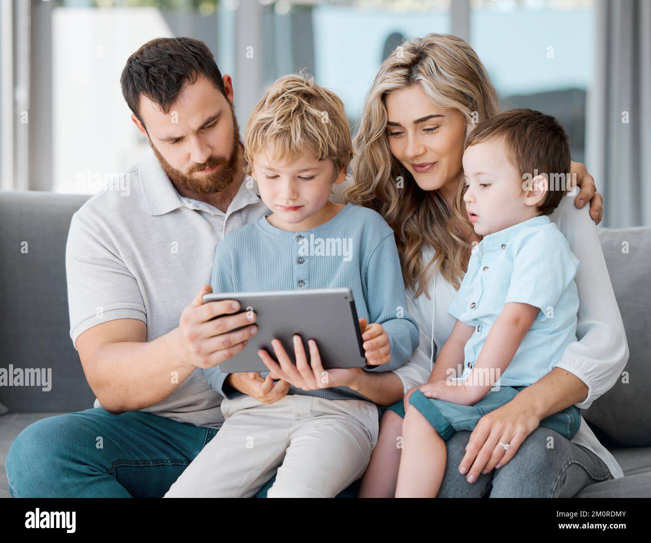 Loving family with two kids sitting at home with device. Caucasian ...
