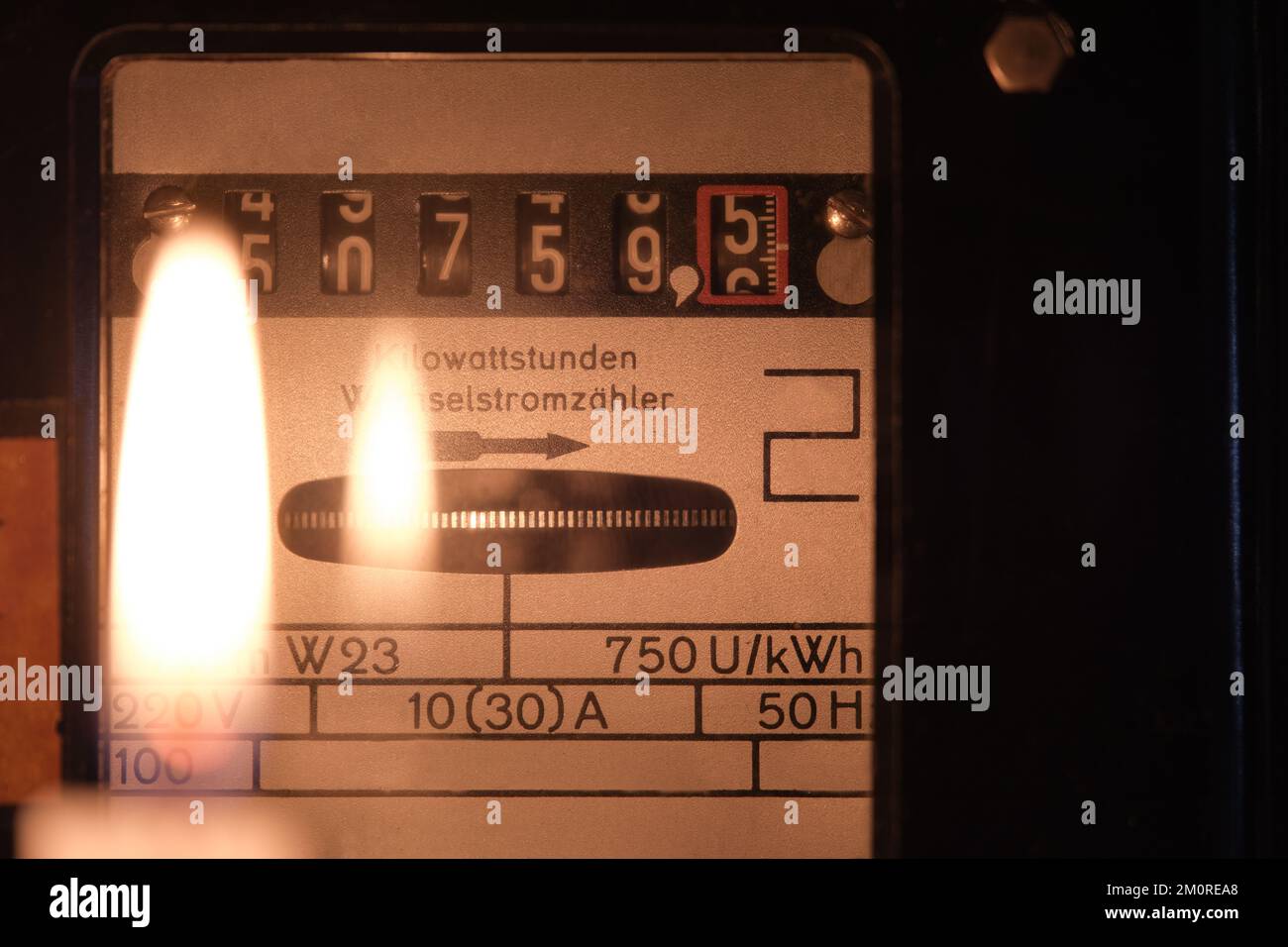 Vintage electric meter with candle light in front. Checking the ...