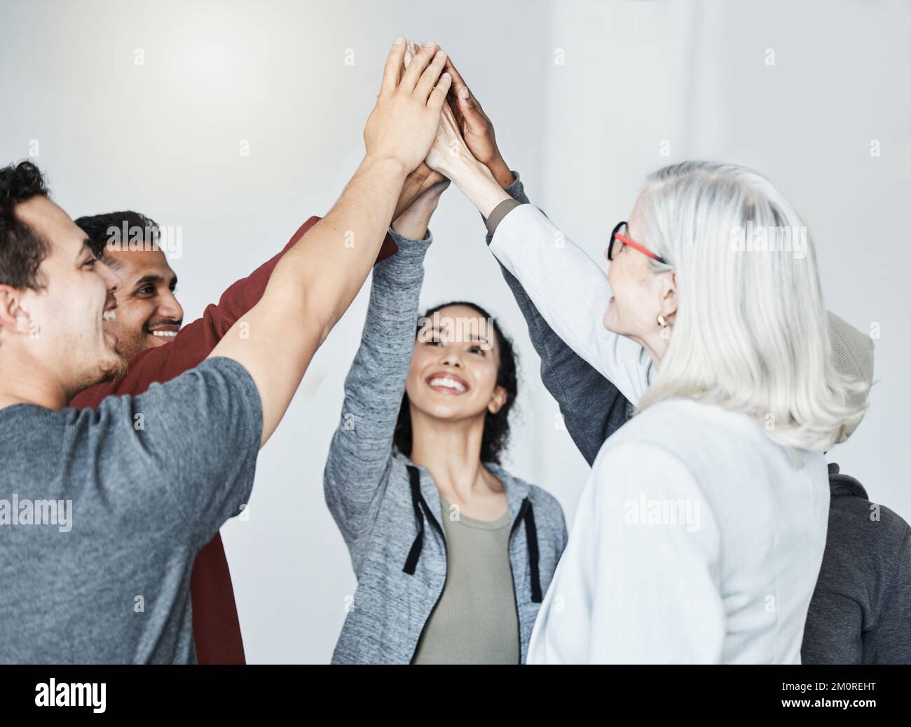 Diverse group of five businesspeople smiling giving each other a high ...