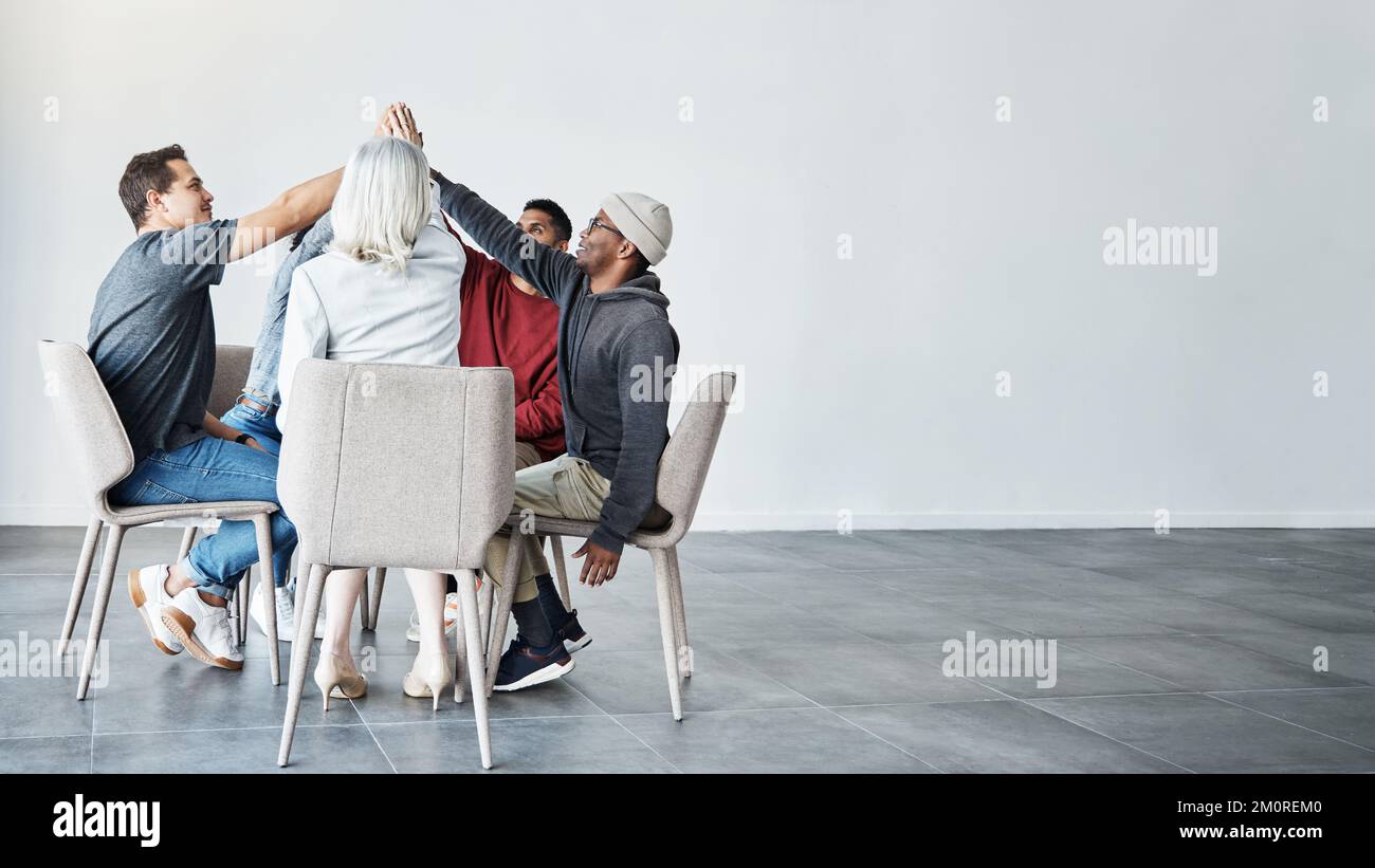 Diverse group of people sitting together and giving each other high ...