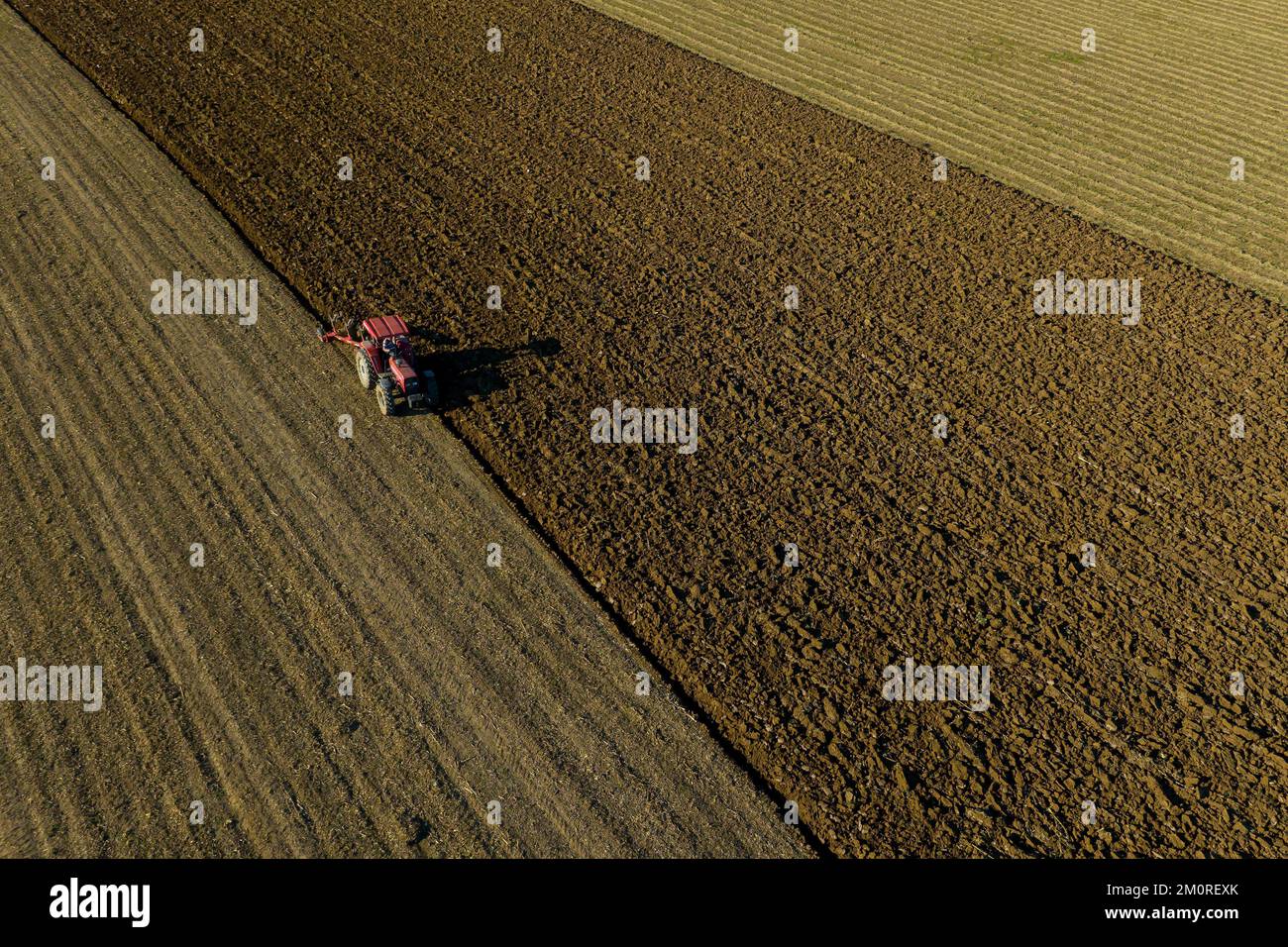 Farm field, farmers work with tractor on farmland Stock Photo - Alamy