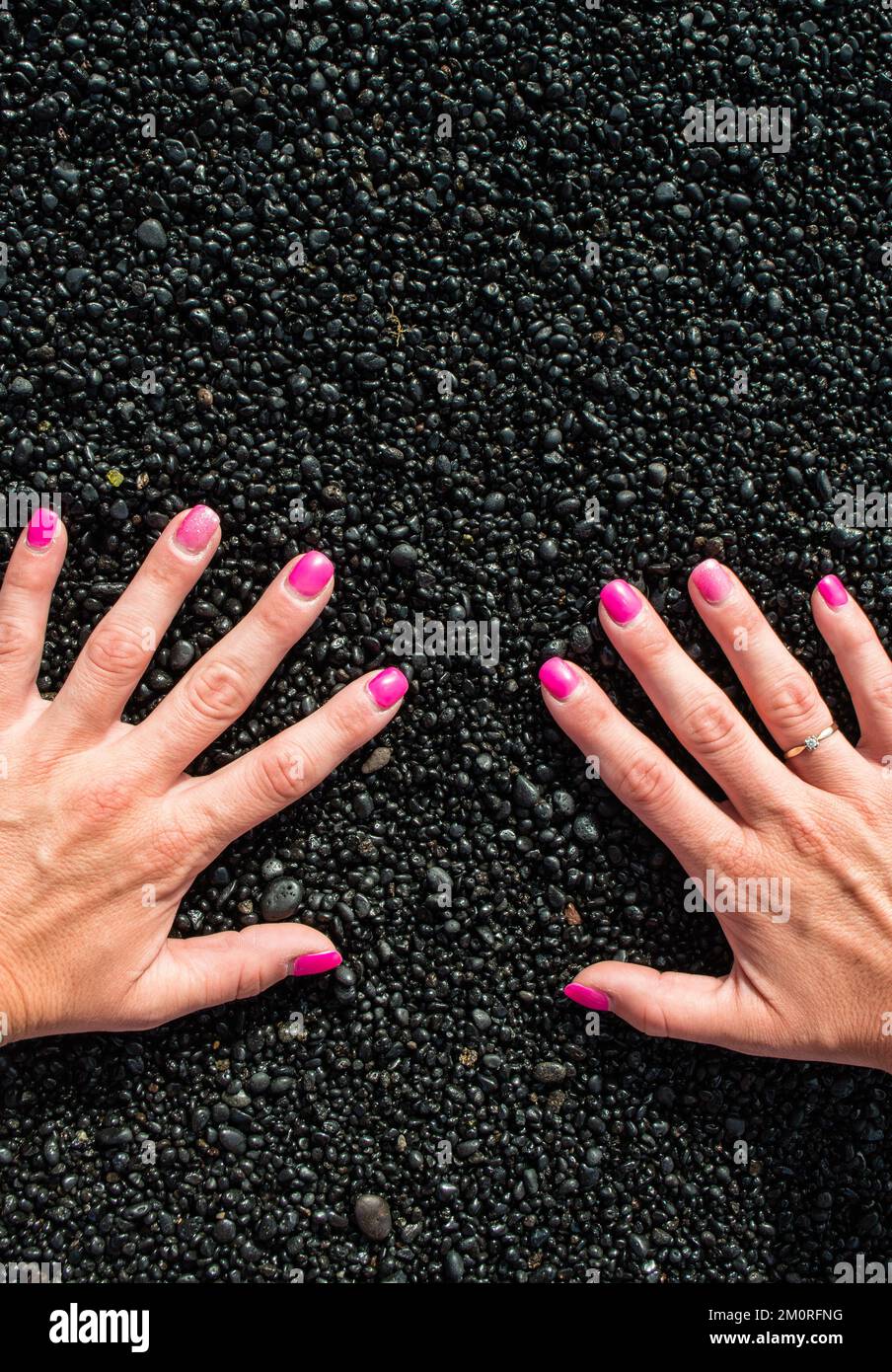 hands and pink nails on the black beach of Lanzarote Stock Photo - Alamy