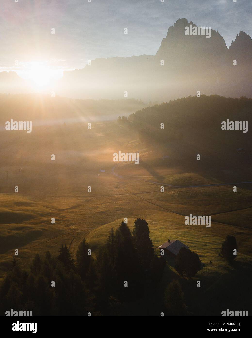 A scenic view of greenfields and the rocky Dolomite mountains in the ...