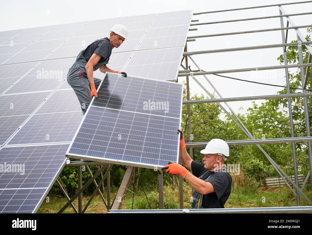 Male worker in safety construction helmet giving solar module to ...