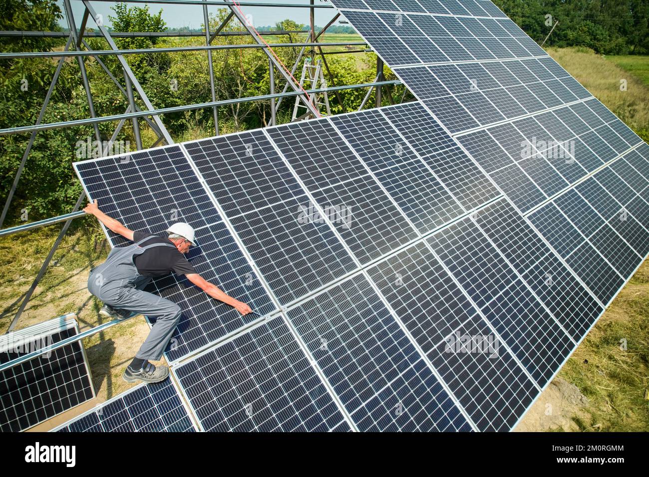 Worker installing solar panels in field at sunny day. European man ...