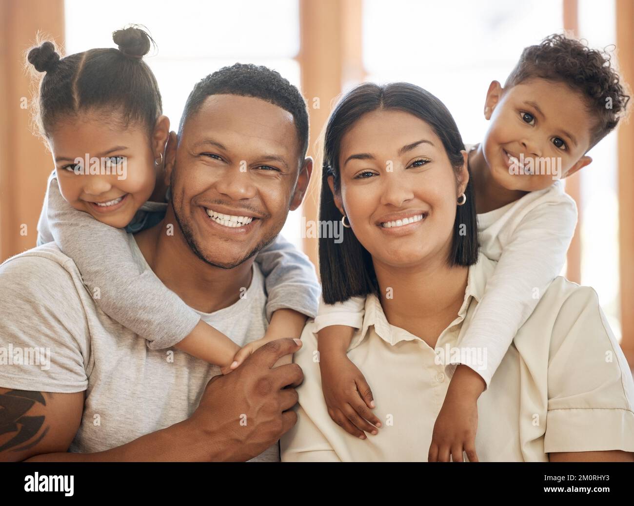 Portrait of smiling mixed race family relaxing together at home ...