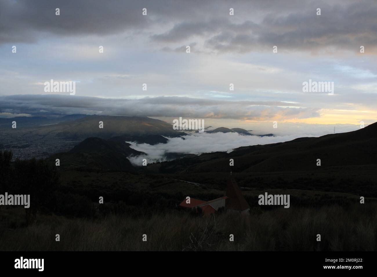 A sunset scene of Clouds moving through the Andes mountains of Quito ...