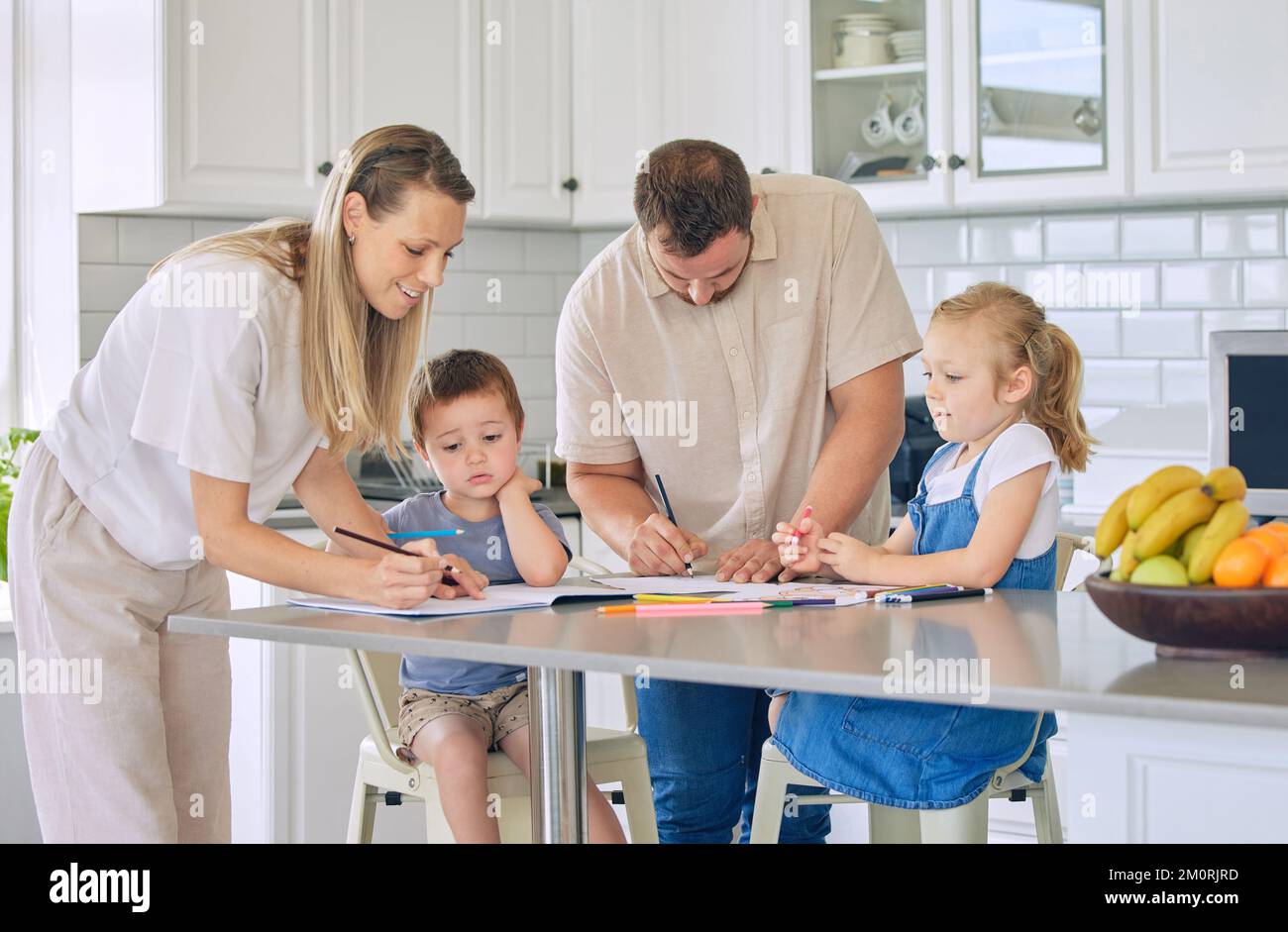 Caucasian parents helping children with homework. Two siblings doing school work. Mother helping ...