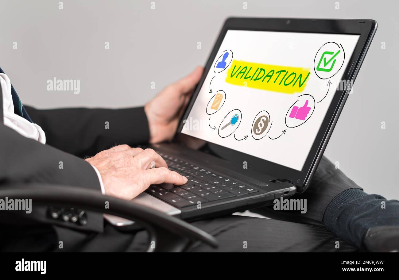 Businessman watching validation concept on a laptop Stock Photo - Alamy